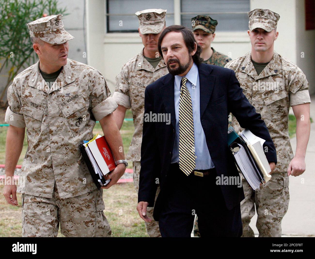Marine Corps Sgt. Lawrence Hutchins, right, is escorted into his ...