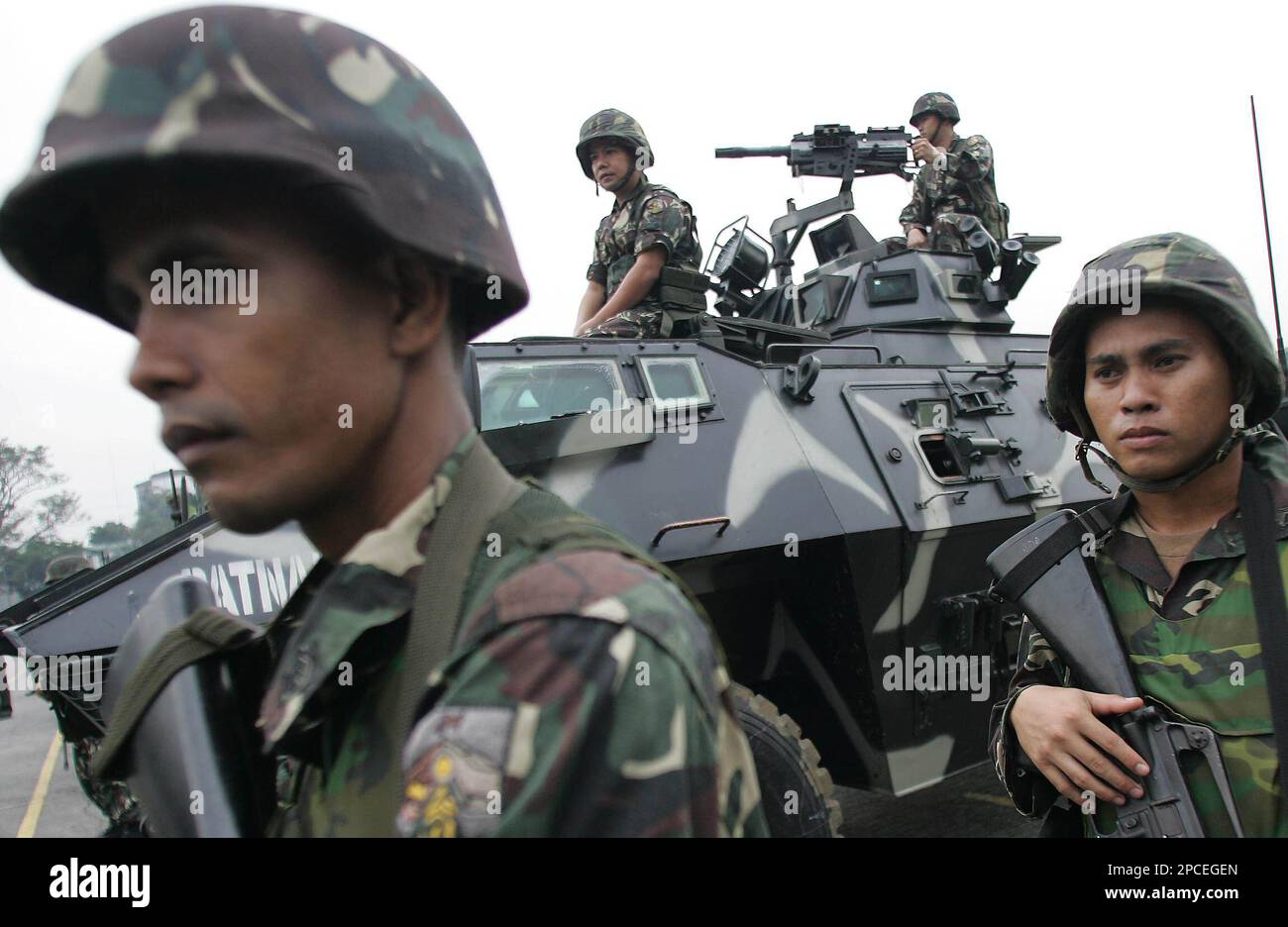 Filipino troopers stand beside an armored personnel carrier during an ...