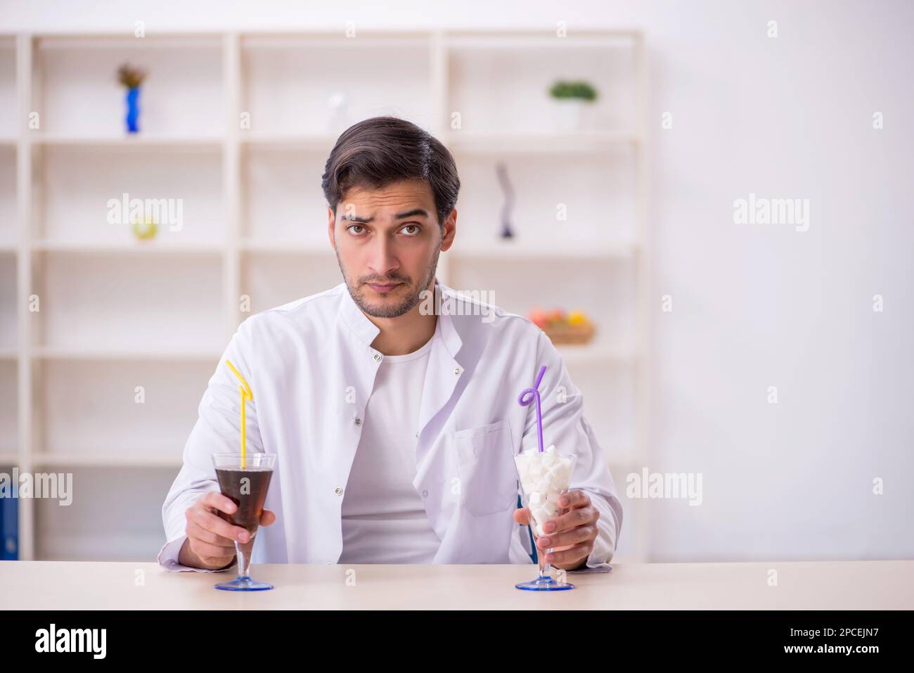 Young chemist examining soft drink at the lab Stock Photo - Alamy