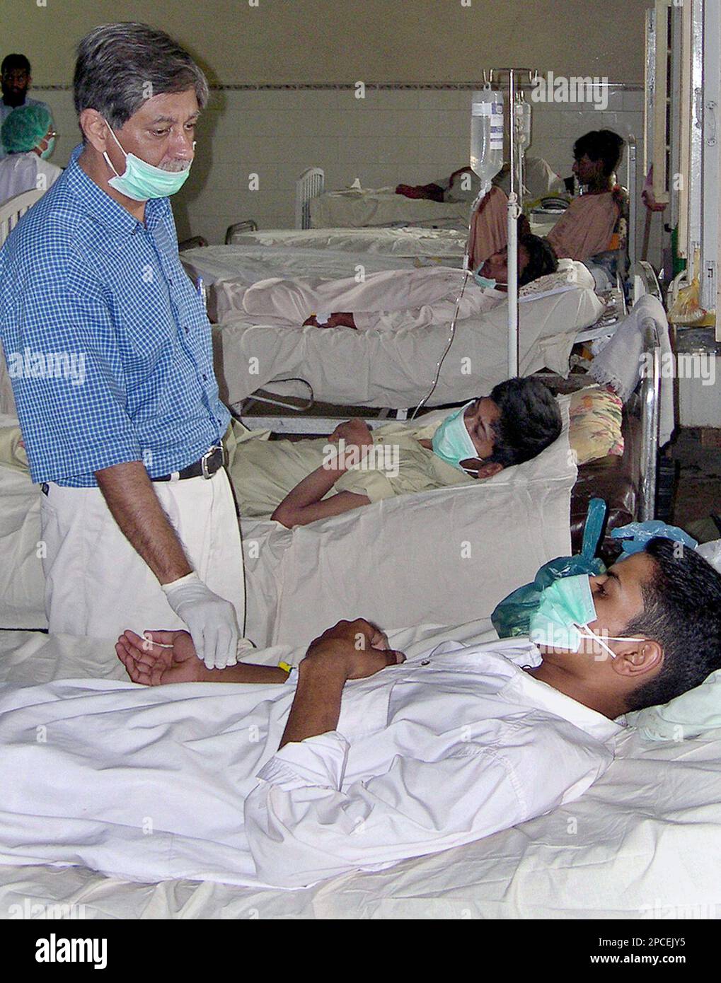 A Pakistani doctor checks the pulse of a patient suffering from dengue ...
