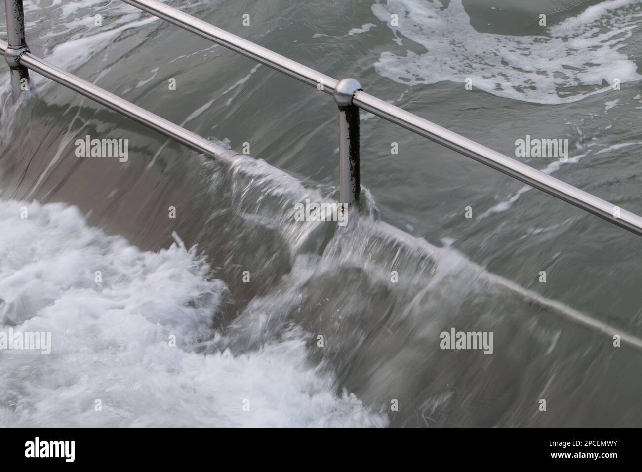 Waves crashing over steps and railings at high tide. Bristol Channel ...