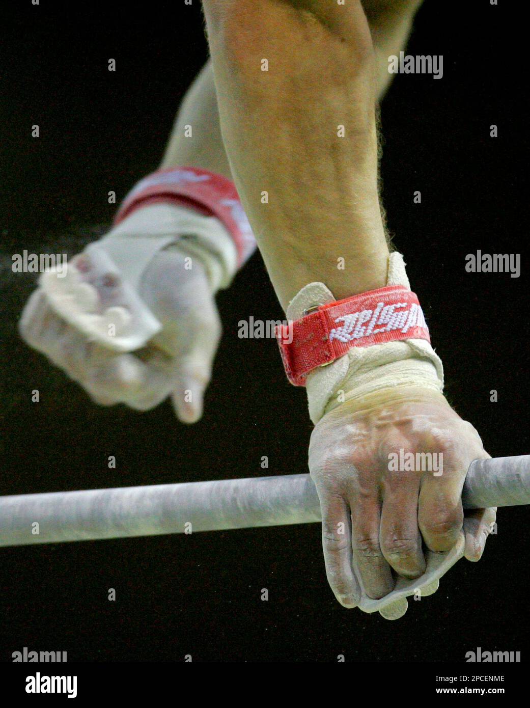 A British competitor grips the bar whilst performing on the horizontal ...