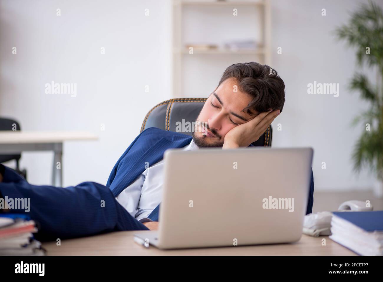 Young businessman employee extremely tired at workplace Stock Photo - Alamy