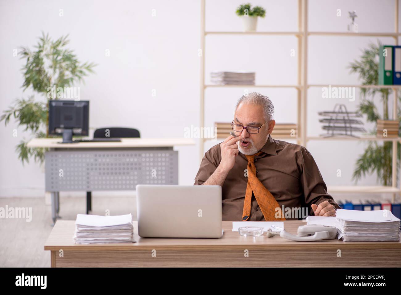 Old businessman employee smoking cigarette at workplace Stock Photo - Alamy