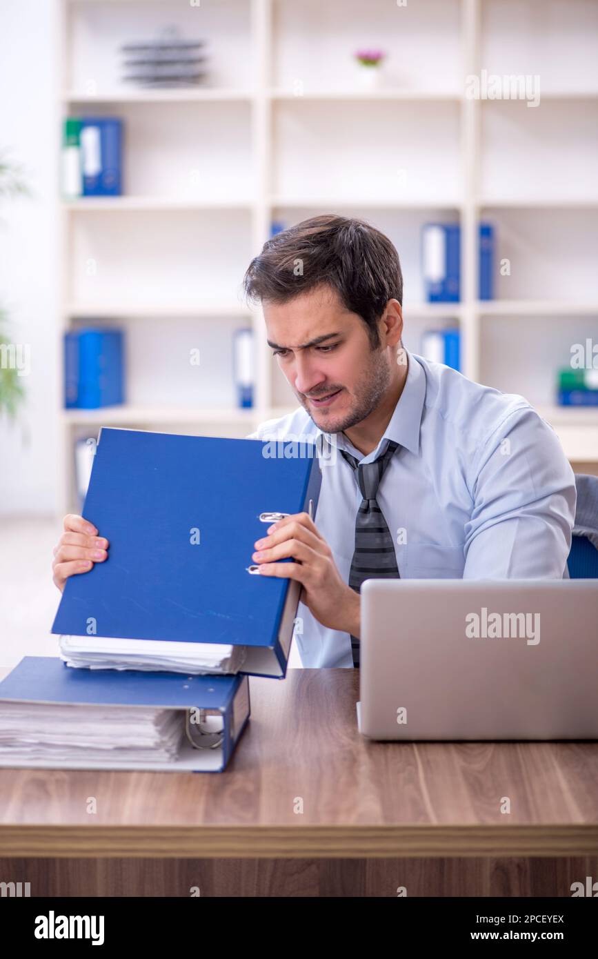 Young employee unhappy with excessive work in the office Stock Photo ...