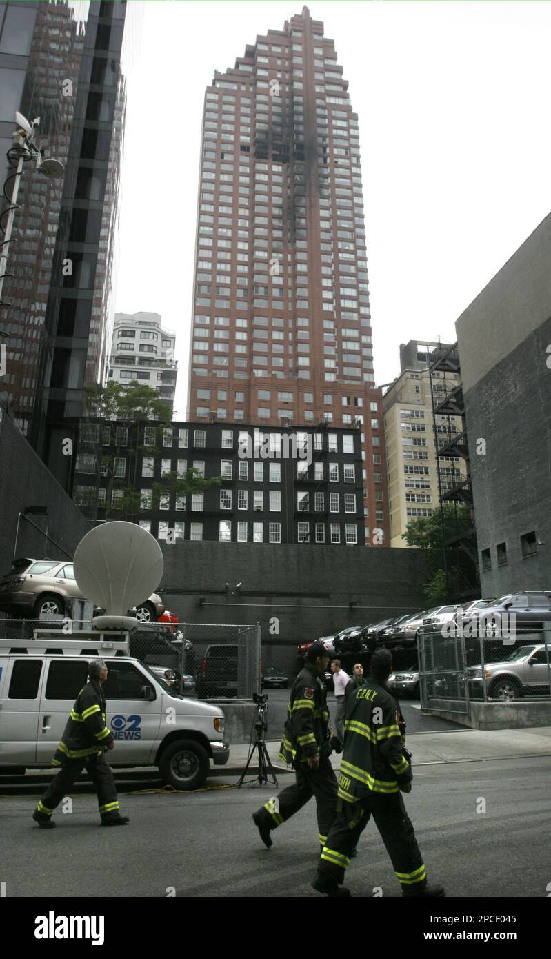 Firefighters survey the area near a high-rise building that was struck ...
