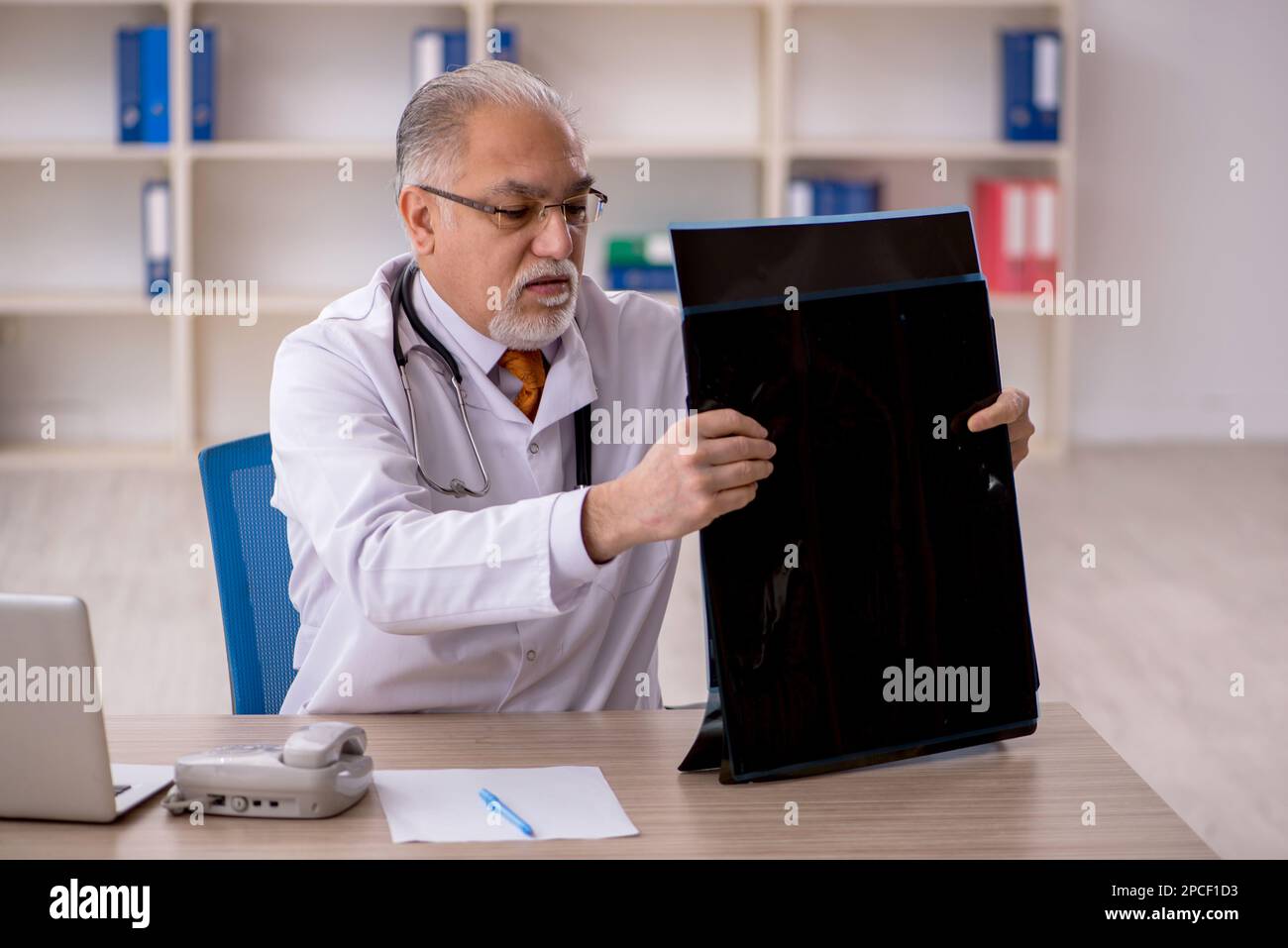 Old doctor radiologist working in the clinic Stock Photo - Alamy