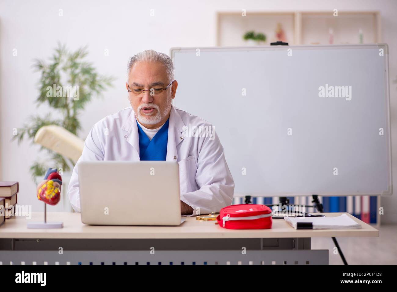 Old doctor cardiologist working at the hospital Stock Photo - Alamy