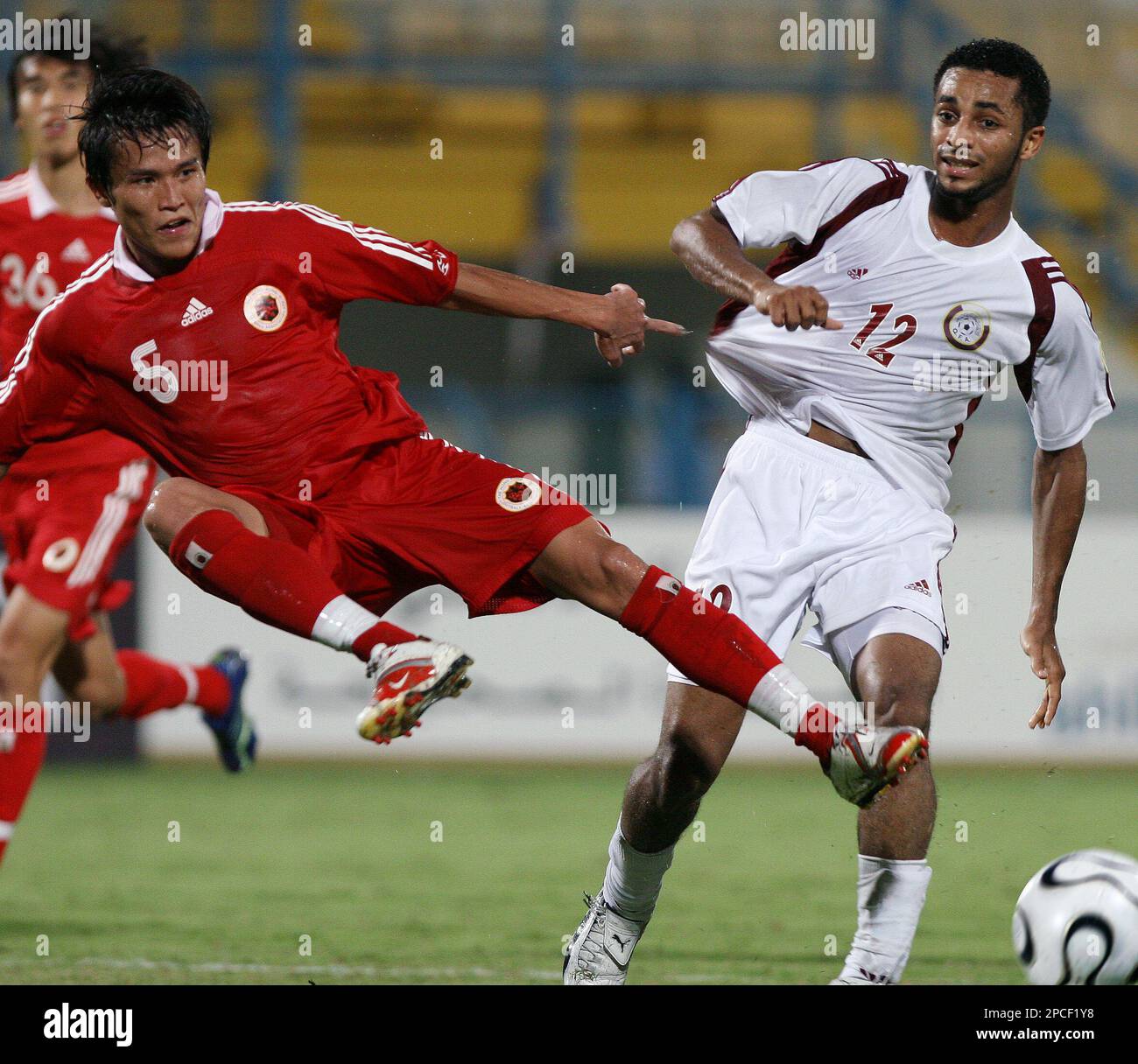 Hong Kong player Lee Wai Lun (L) challenges with Qatar's Hassan Magid ...