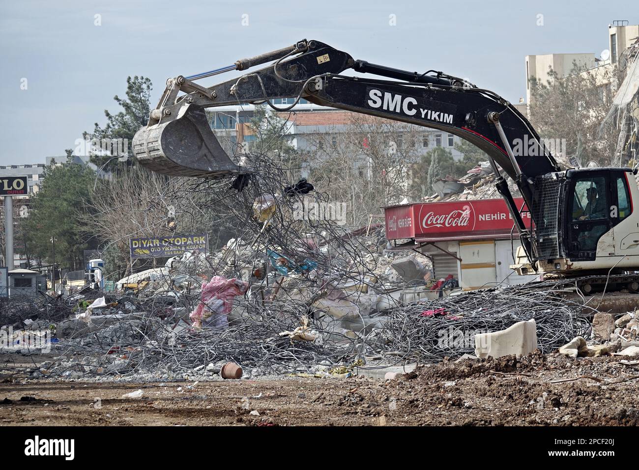 A backhoe loader clearing debris by decomposing construction irons ...