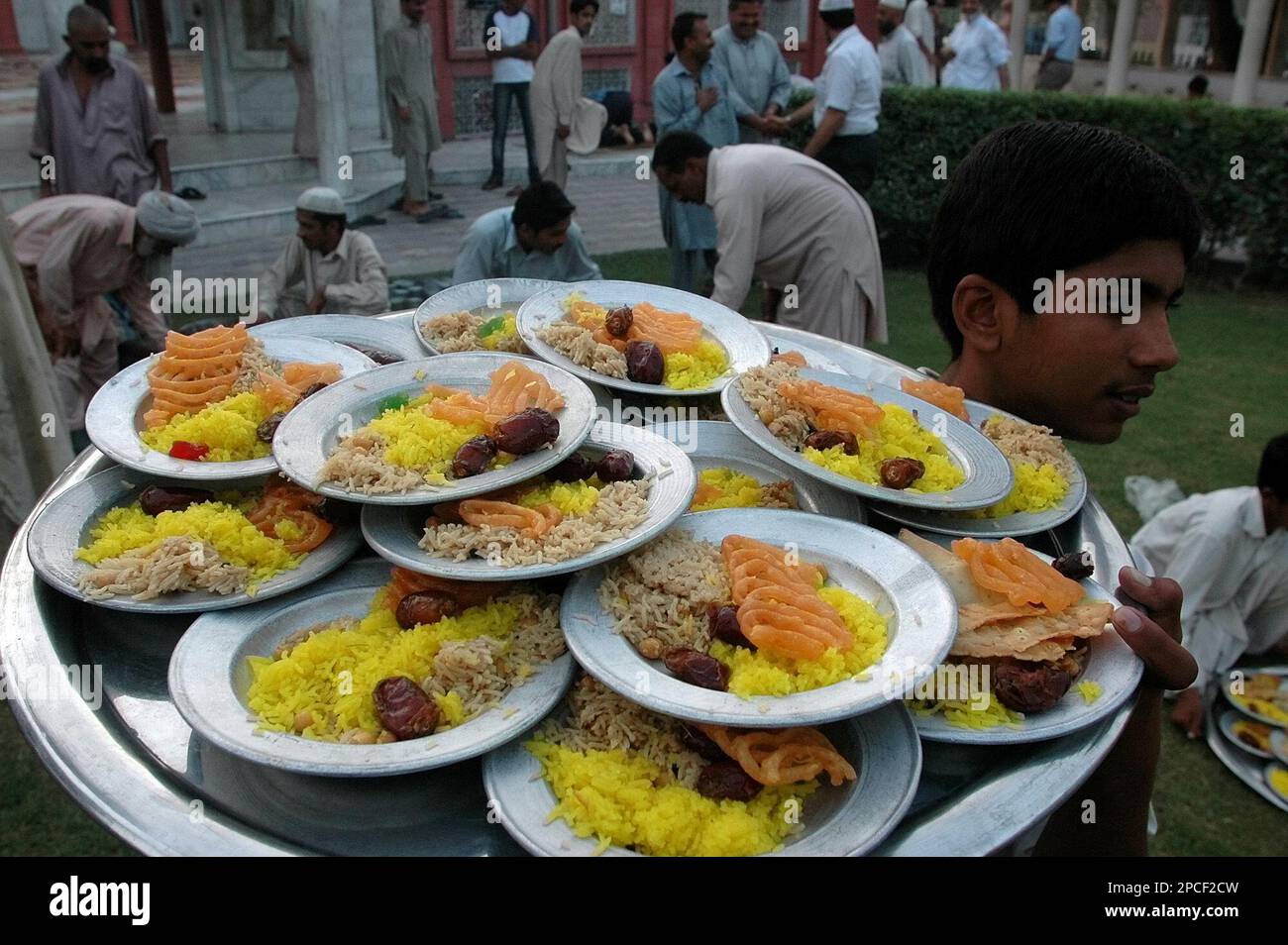 A Pakistani boy carries food for people to break their fast in Lahore ...