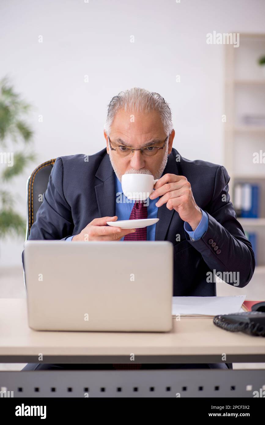 Old businessman employee drinking coffee during break Stock Photo - Alamy