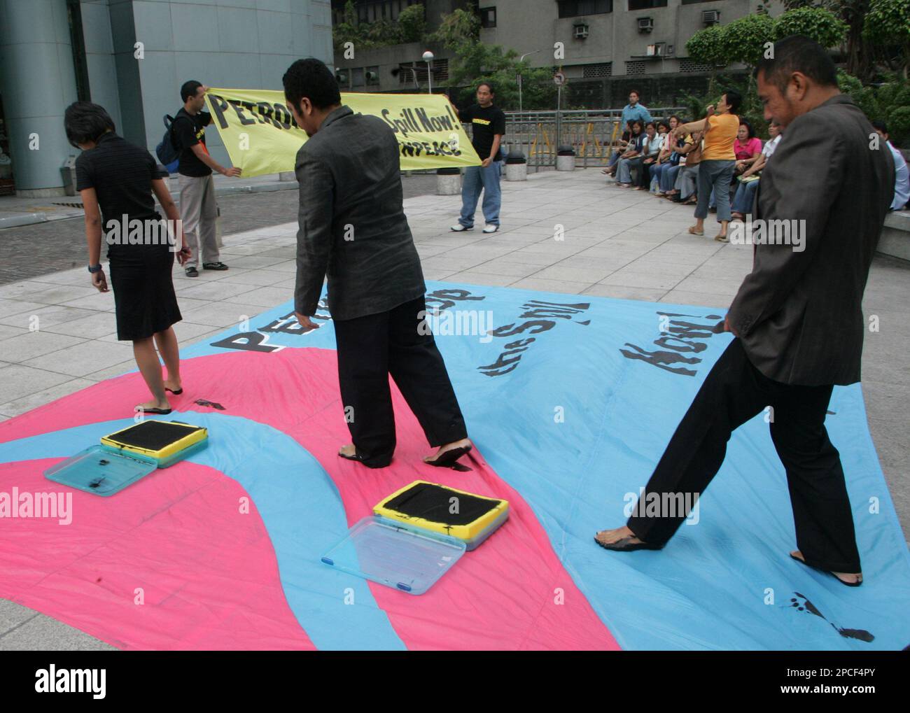 Greenpeace activists leave oil footprints on the giant banner imitating ...