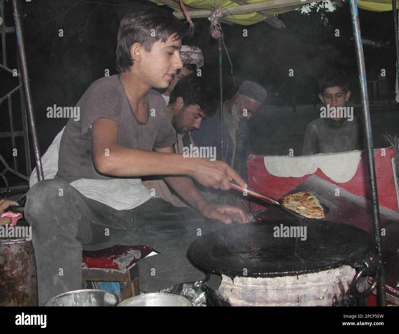An Afghan boy makes bulani made with potato and flour in Kabul ...