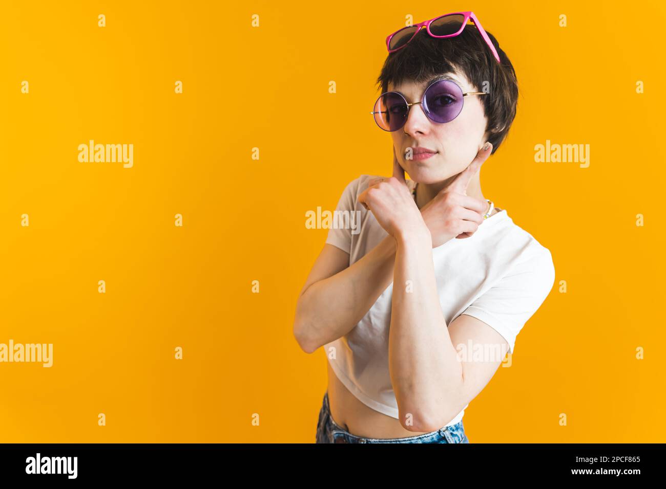 Young woman with her hands crossed under her chin wearing two pairs of ...
