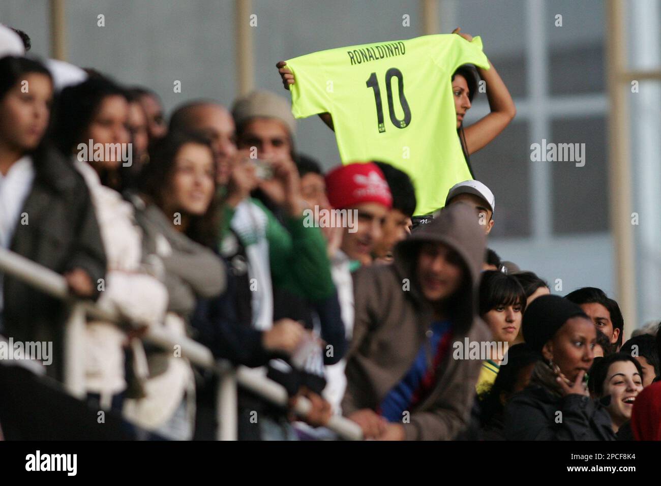 A fan holds up a Ronaldinho shirt as thousands of fans watch Brazil ...