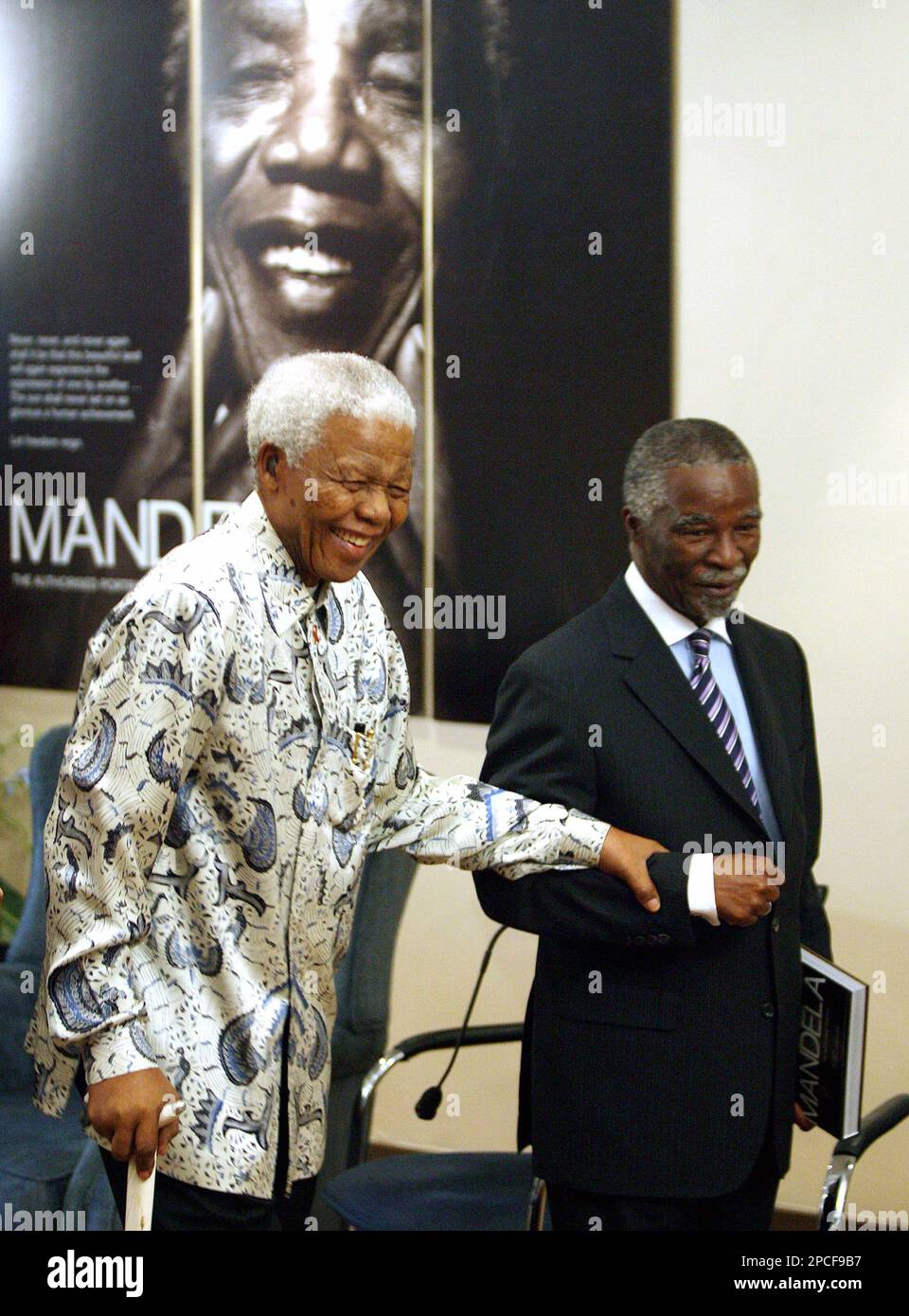 Former South African President Nelson Mandela is helped by South African President Thabo Mbeki ...