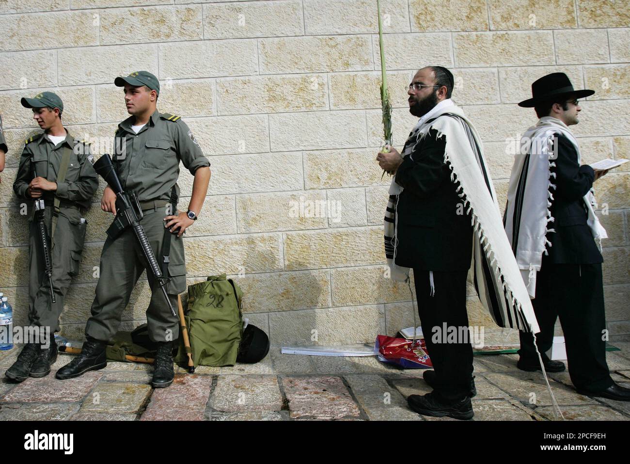 Israeli border policemen, left, stand guard while Ultra-orthodox Jews ...