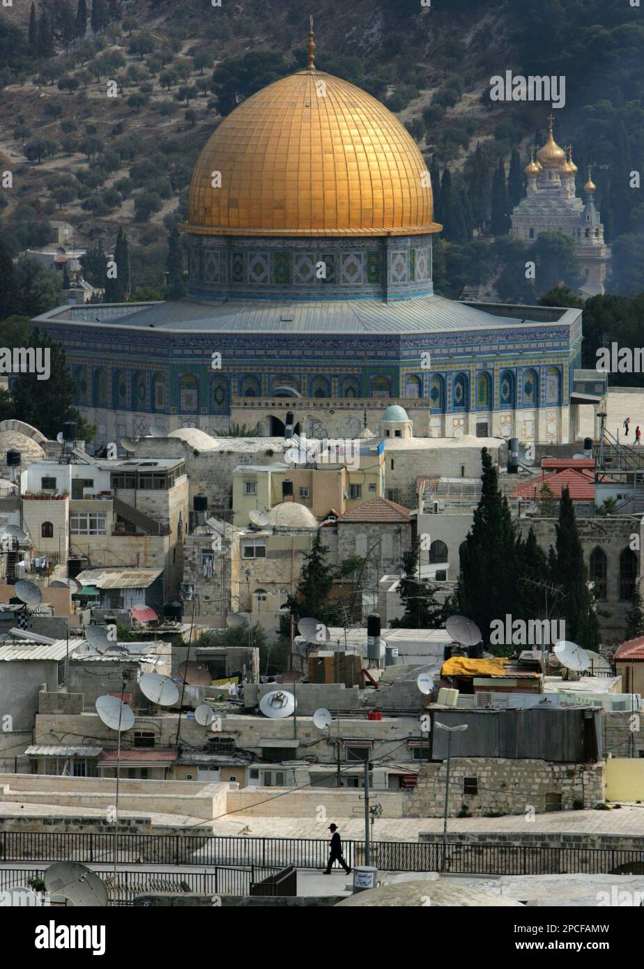 An ultra-Orthodox Jewish man walks with the background of the Dome of ...