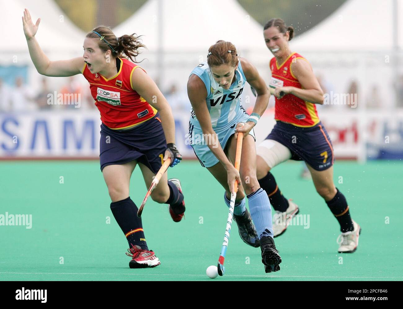 Argentina's Luciana Aymar, center, runs past Spain's Maria Romagosa ...