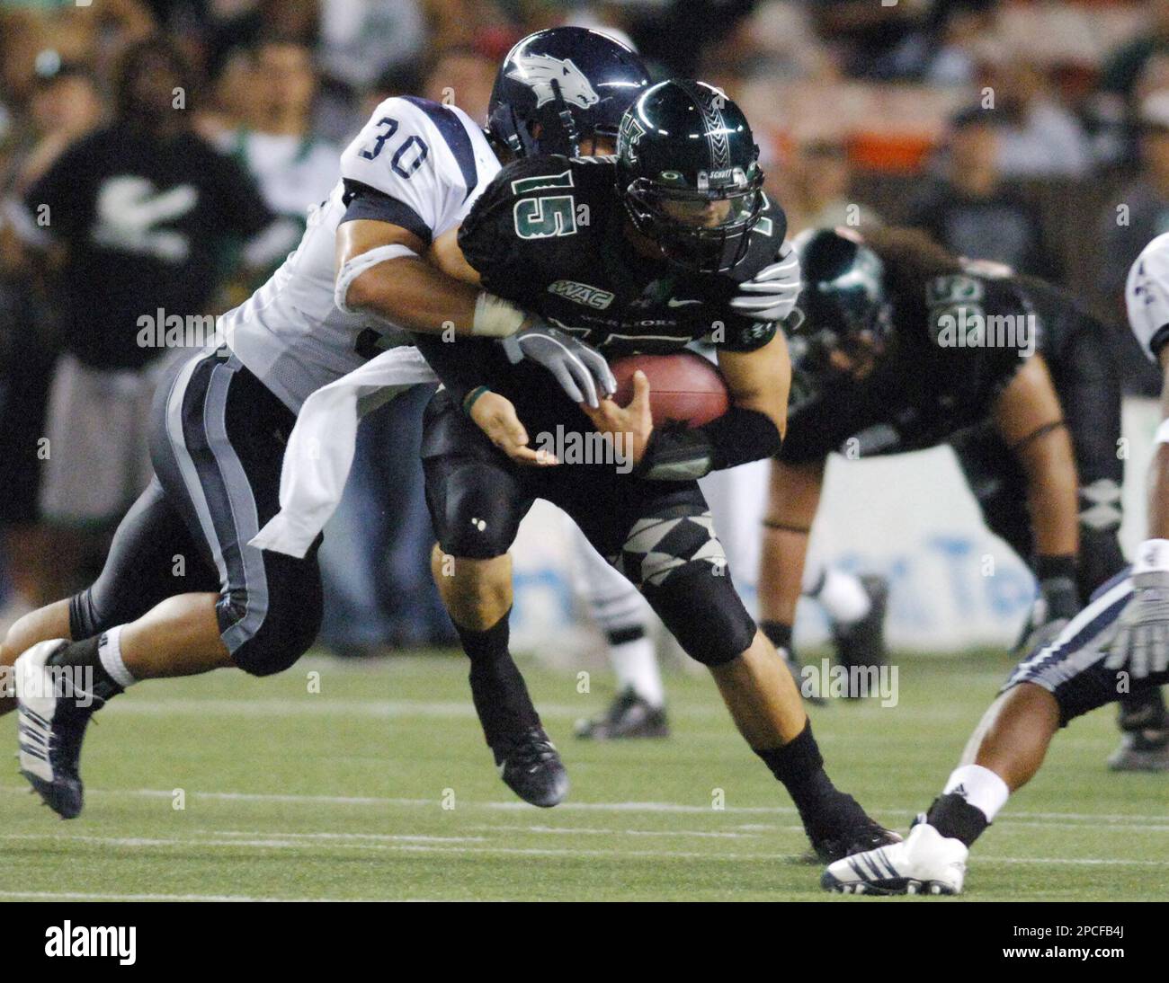 Hawaii quarterback Colt Brennan is sacked by Nevada's Joshua Mauga (30 ...