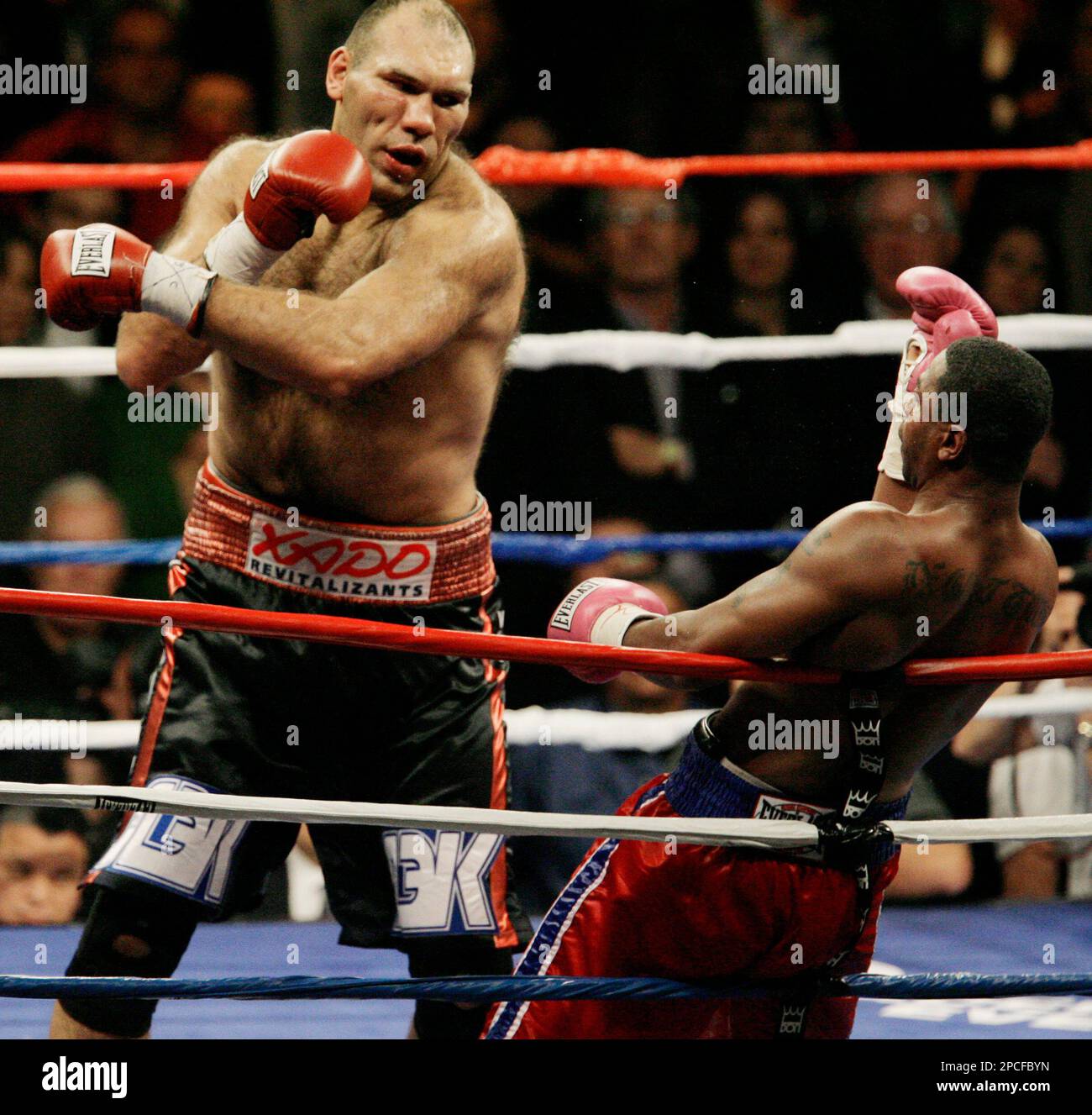 Nikolai Valuev , left, of Russia lands a punch that puts Monte Barrett ...