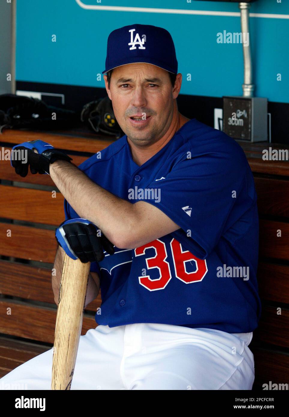 Los Angeles Dodgers pitcher Greg Maddux sits in the dugout with his bat ...
