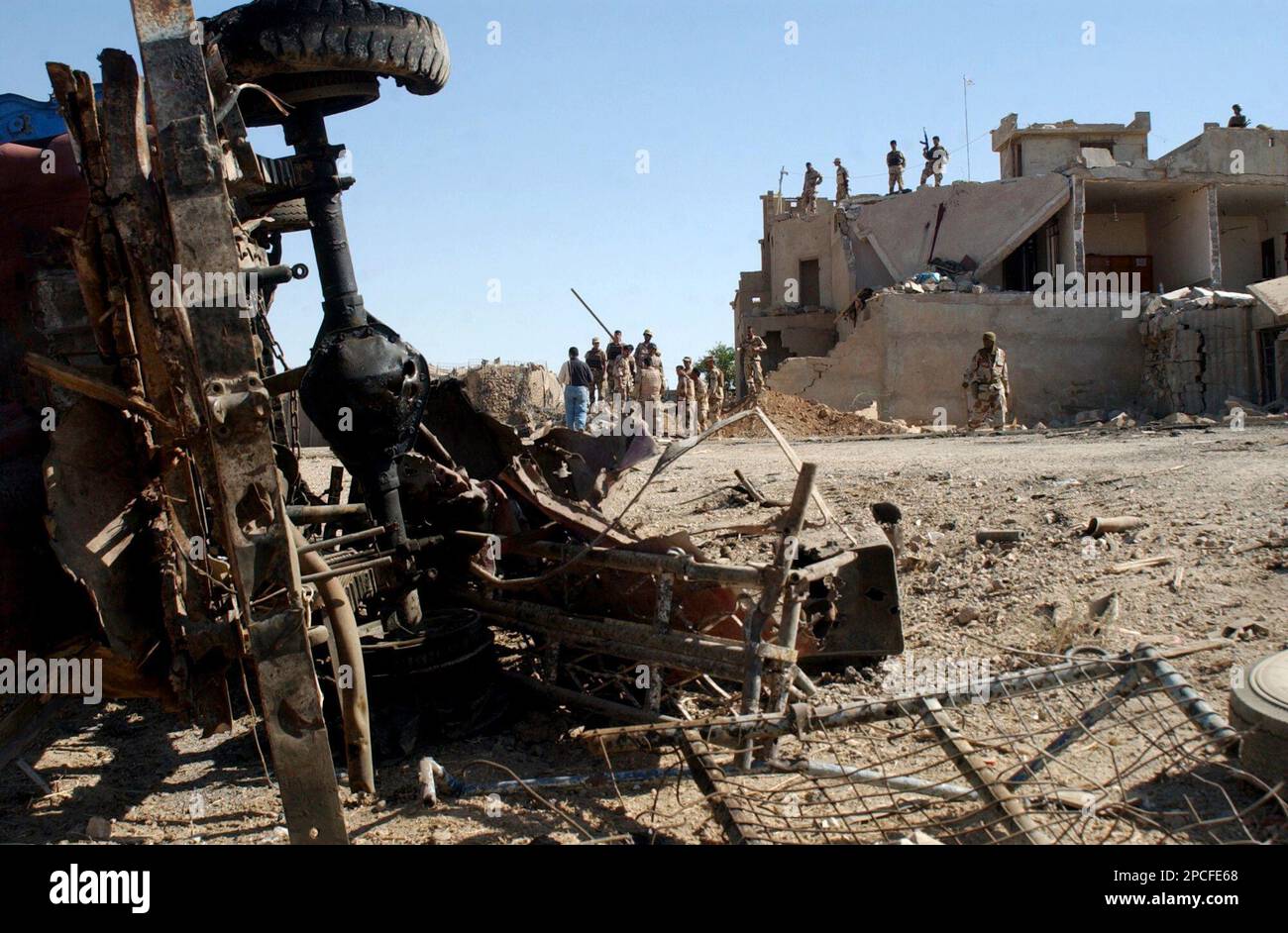 Iraqi army soldiers stand at the spot where a suicide bomber rammed a ...