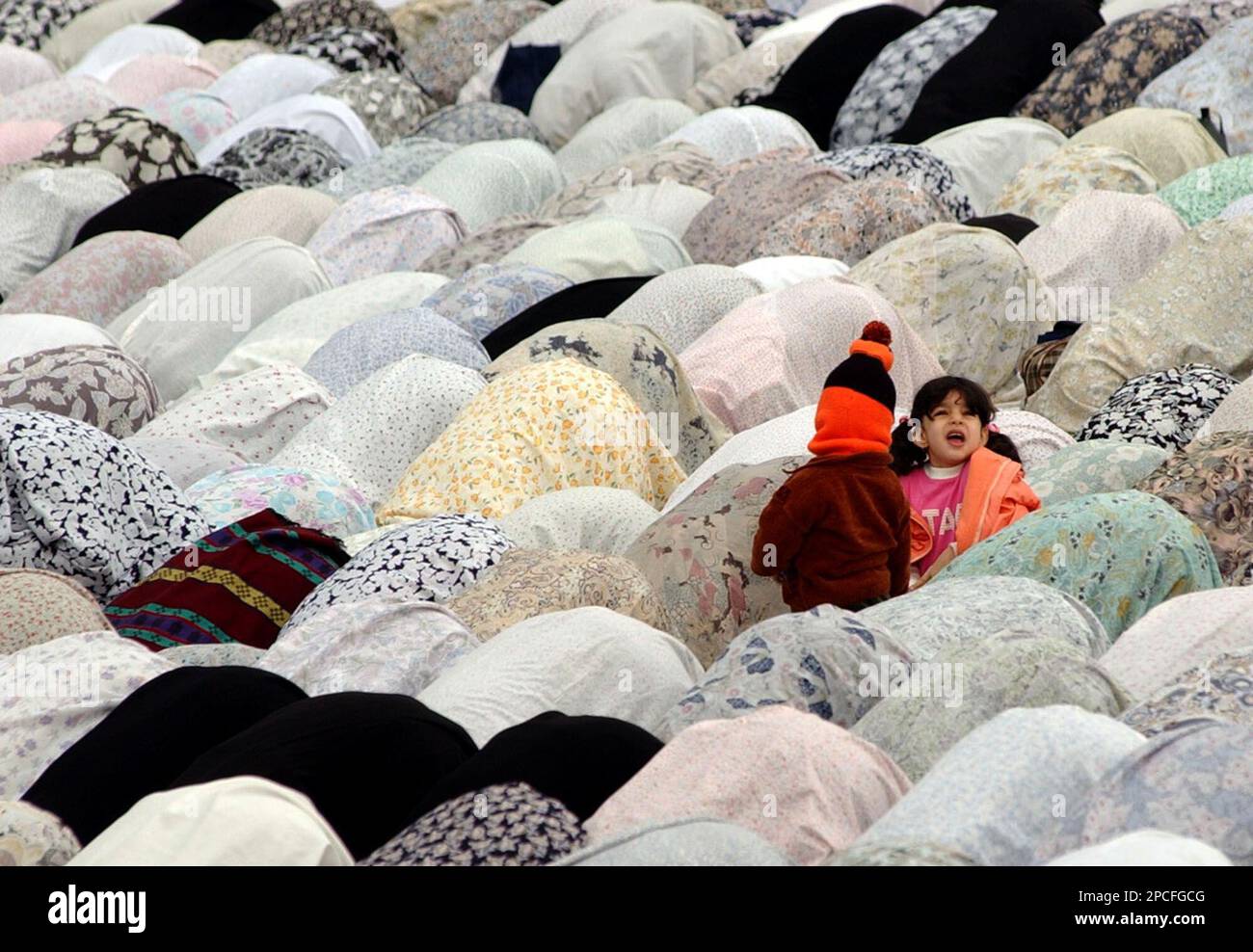 Two children sit as Iranian Muslim women offer morning prayers in ...