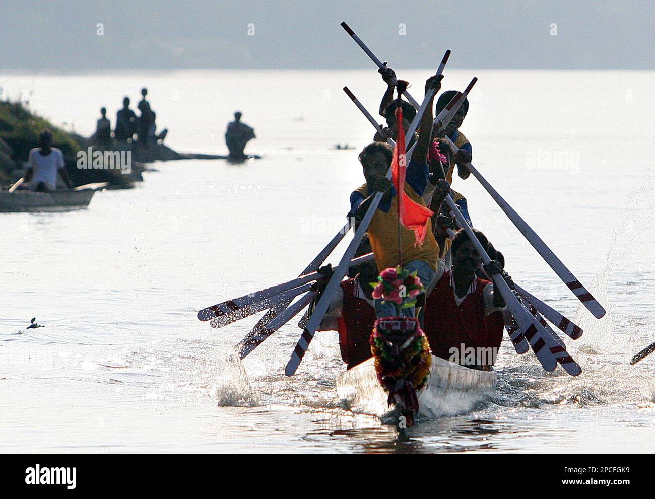 Competitors paddle a country boat during a traditional boat race as ...