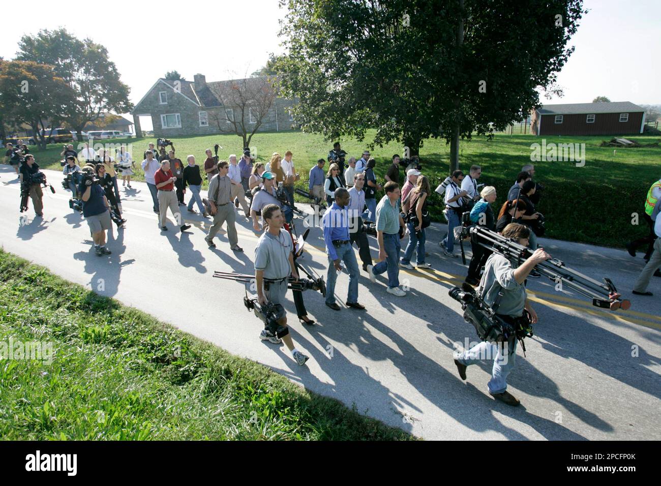 Members of the media, escorted by state police, walk to take a closer ...