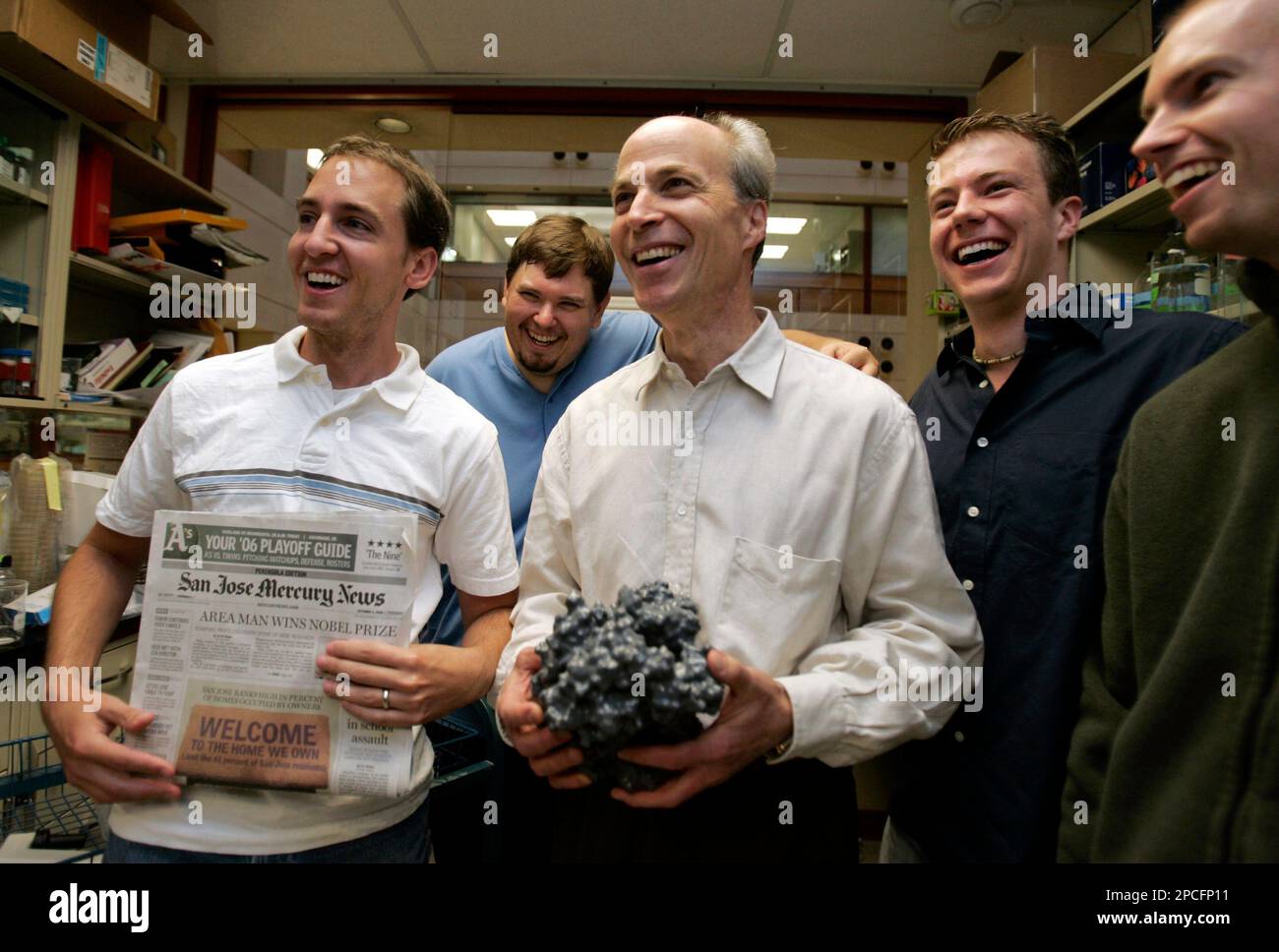 Roger Kornberg, center, of Stanford University, smiles as he hold a ...