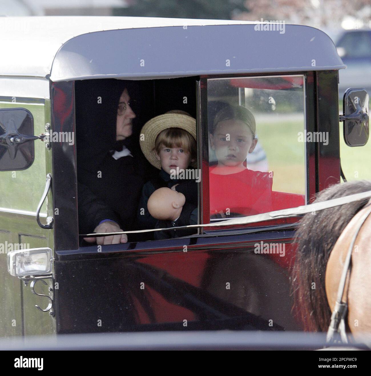 Amish children ride with a woman in a buggy along Mines Road in Nickel ...