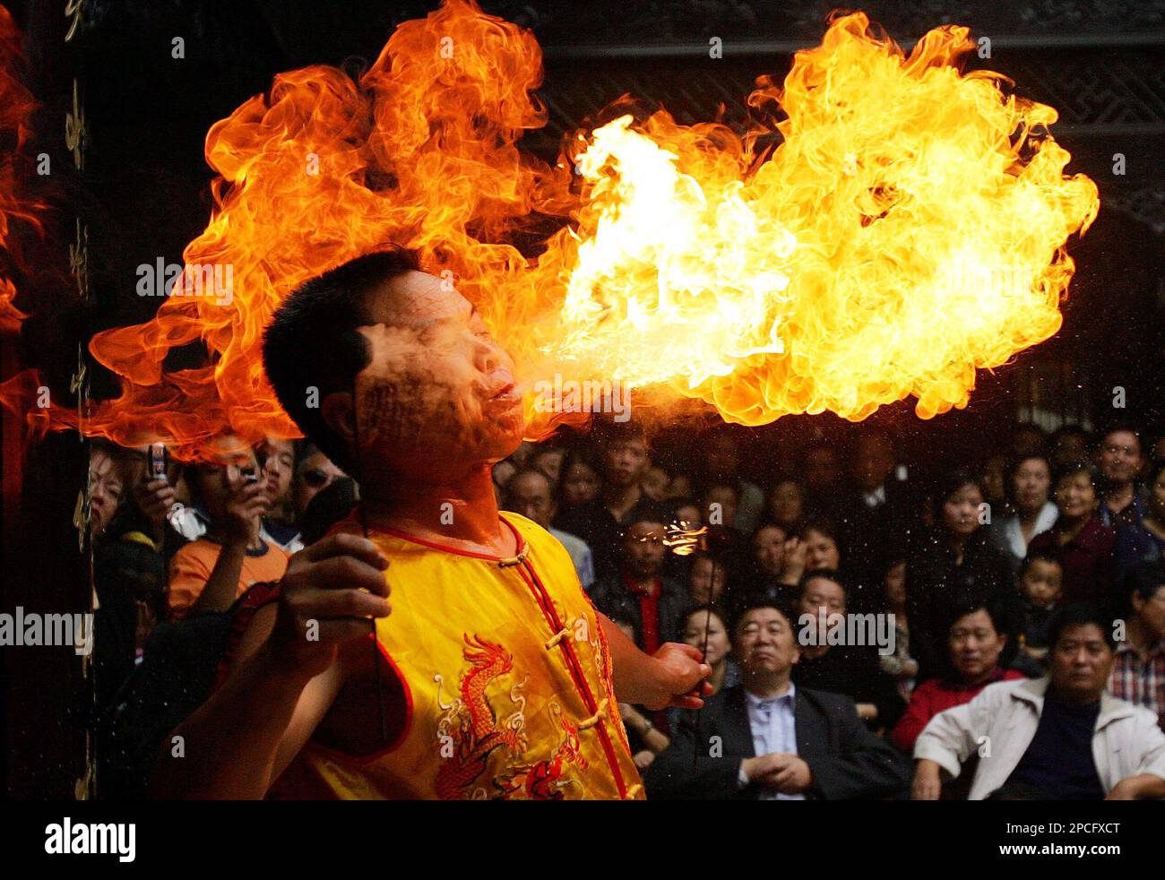 A Chinese man performs "fire spitting" during National Day celebrations ...