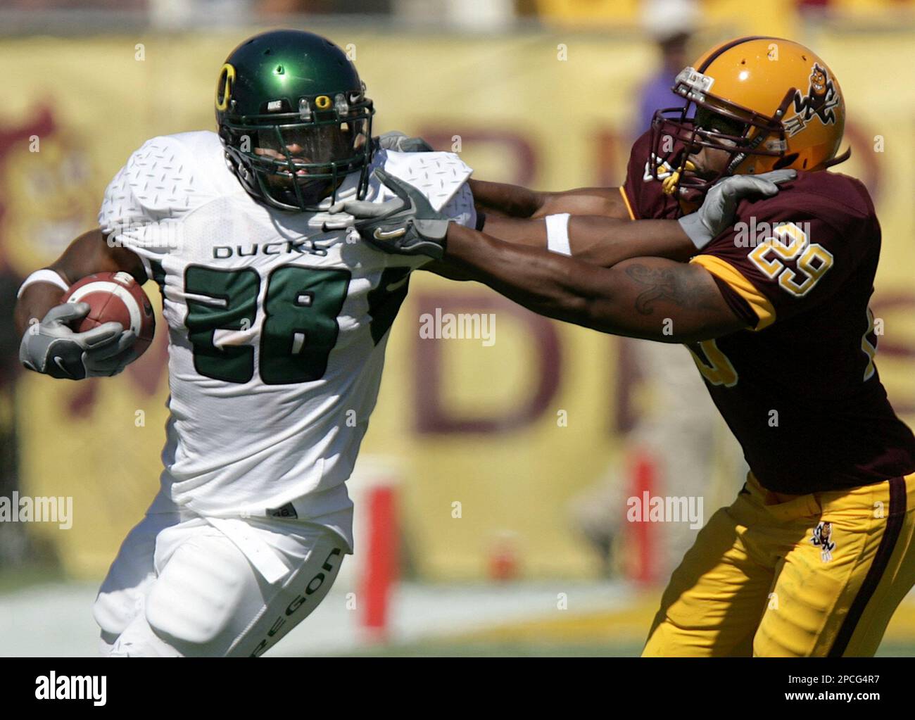 Oregon running back Jonathan Stewart, left, is face-masked by Arizona ...