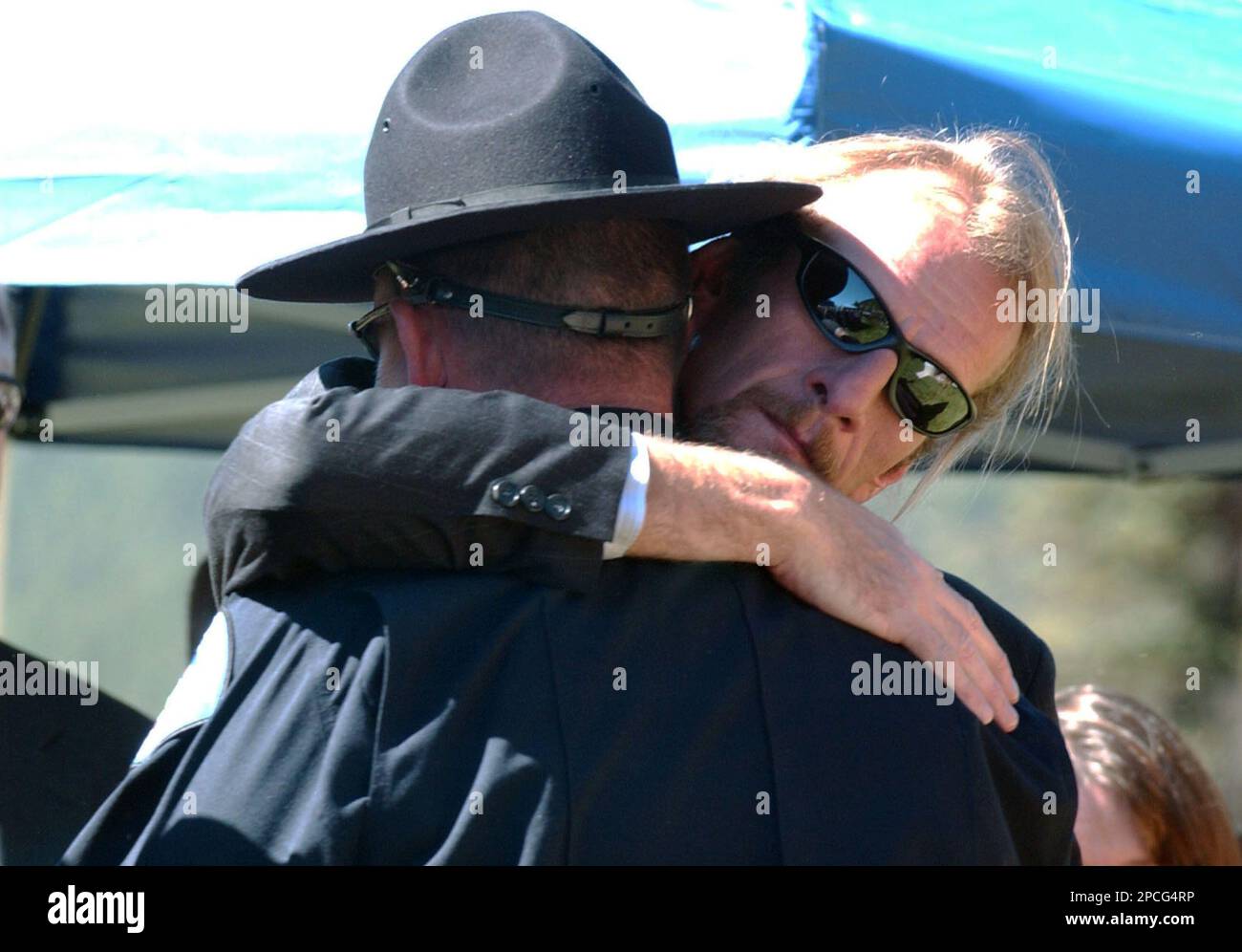 John Michael Keyes, hugs Fred Wegener, sheriff of Park County, Colo ...