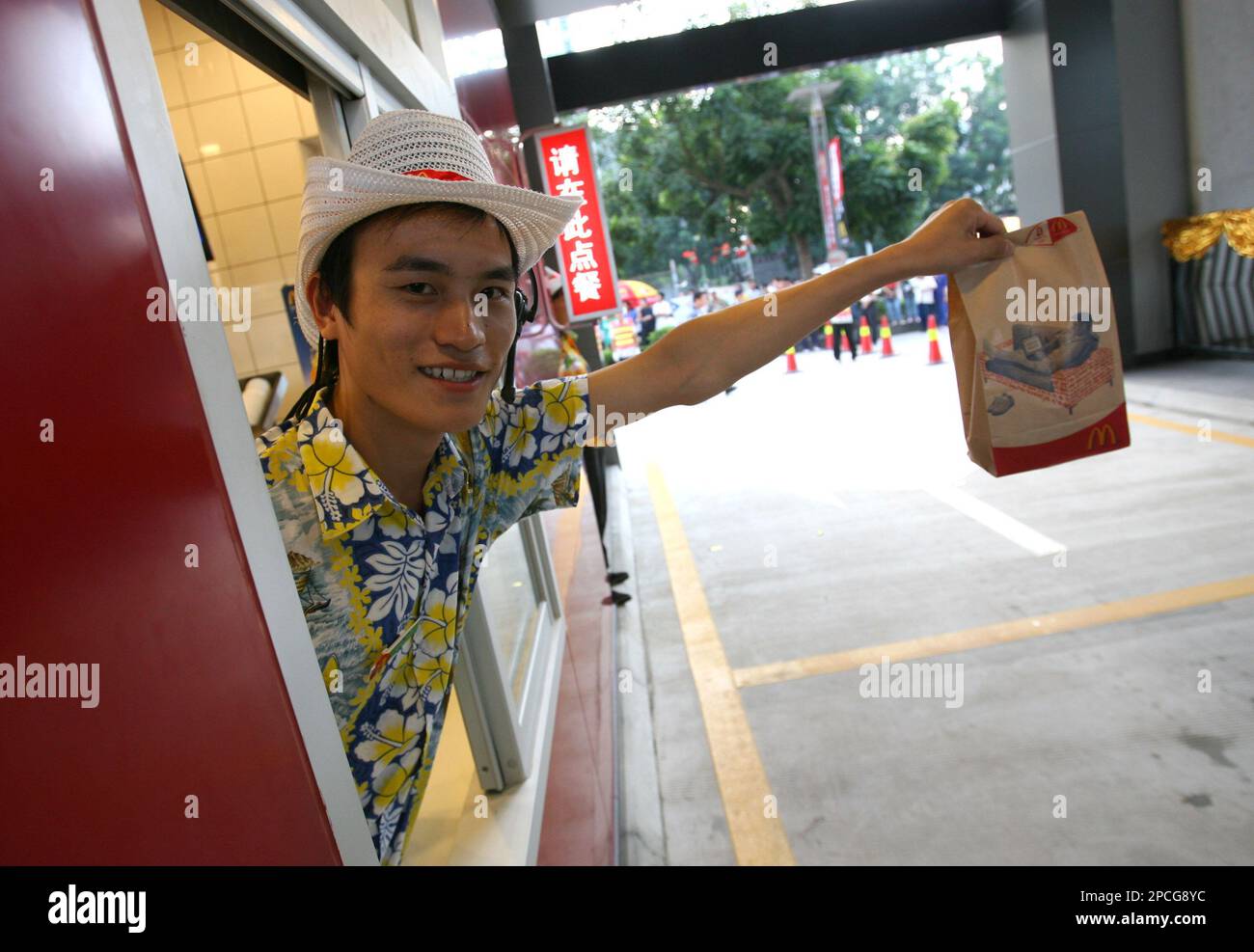 A waiter prepares to hand McDonald's food to a customer at the first ...