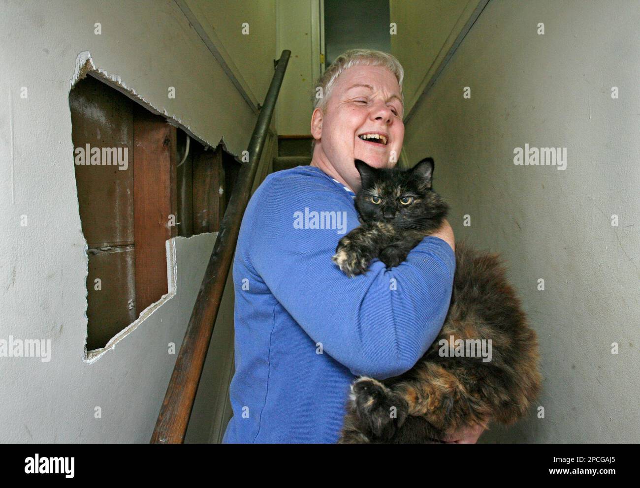 Eva Raymond, hugs her cat, Blacktop, in the stairway of her Richmond ...
