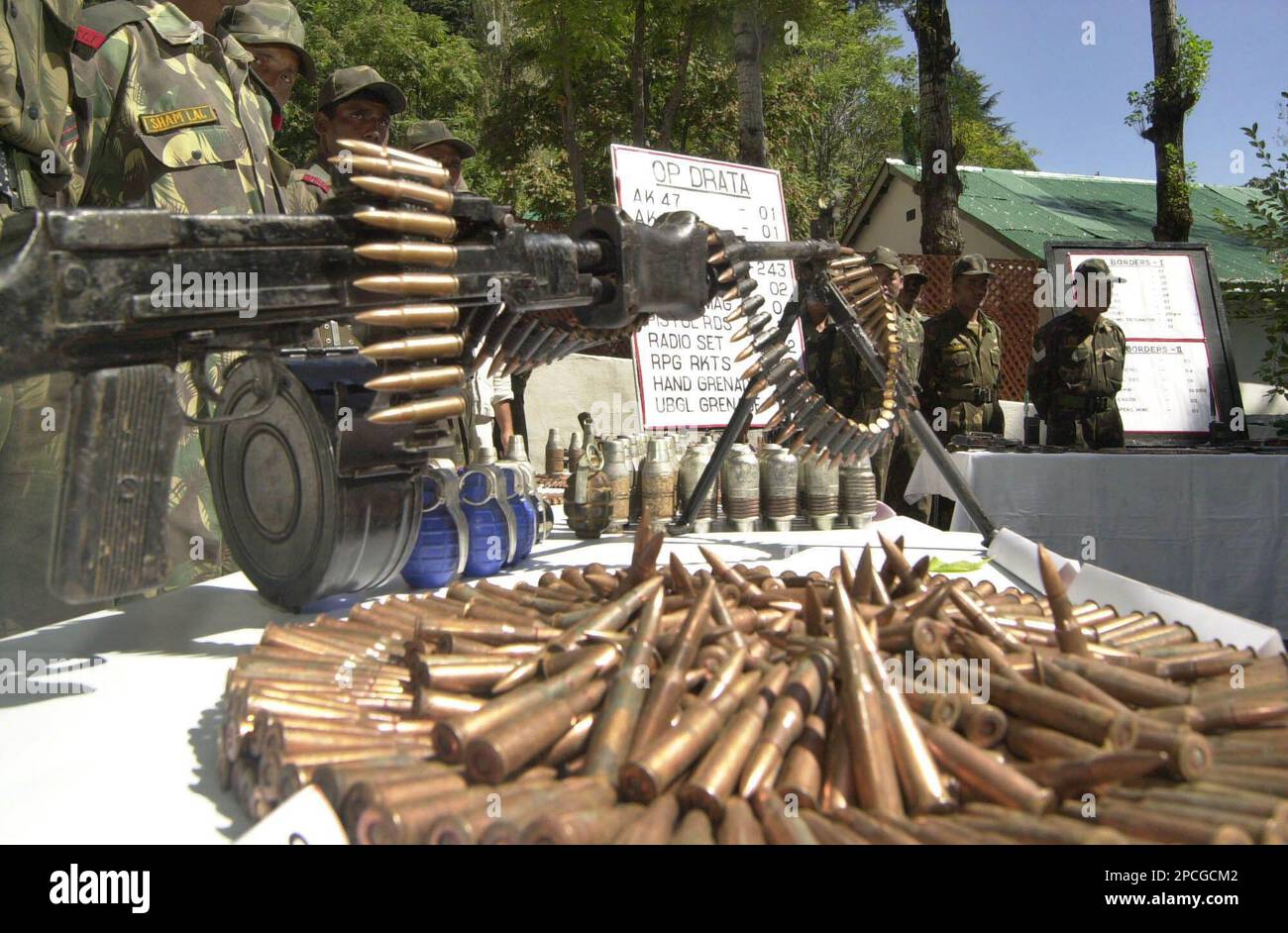 Indian Army officers stand near arms and ammunition recovered from a ...