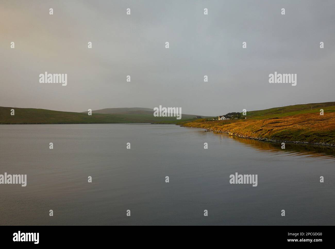 Colour photograph of a lake and houses at sunrise, Collafirth, Shetland ...