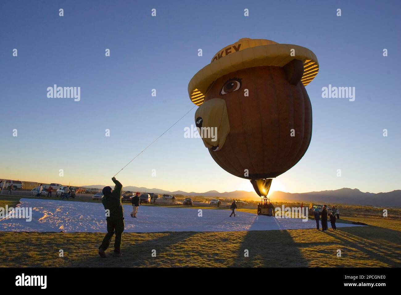 A Smokey the Bear hot air balloon crew member holds a tether line ...