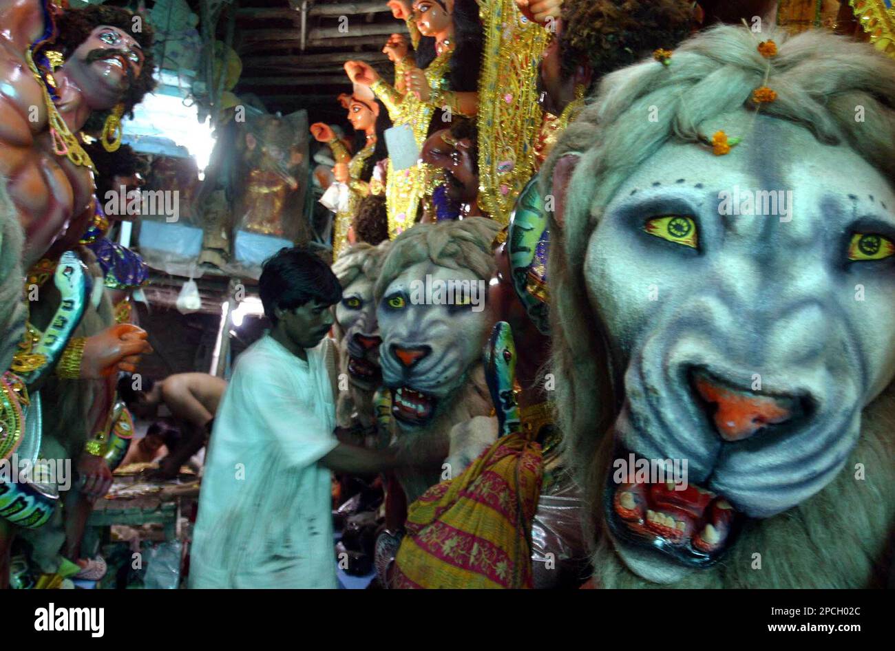 An artist gives finishing touches to an idol of the Hindu Goddess Durga ...