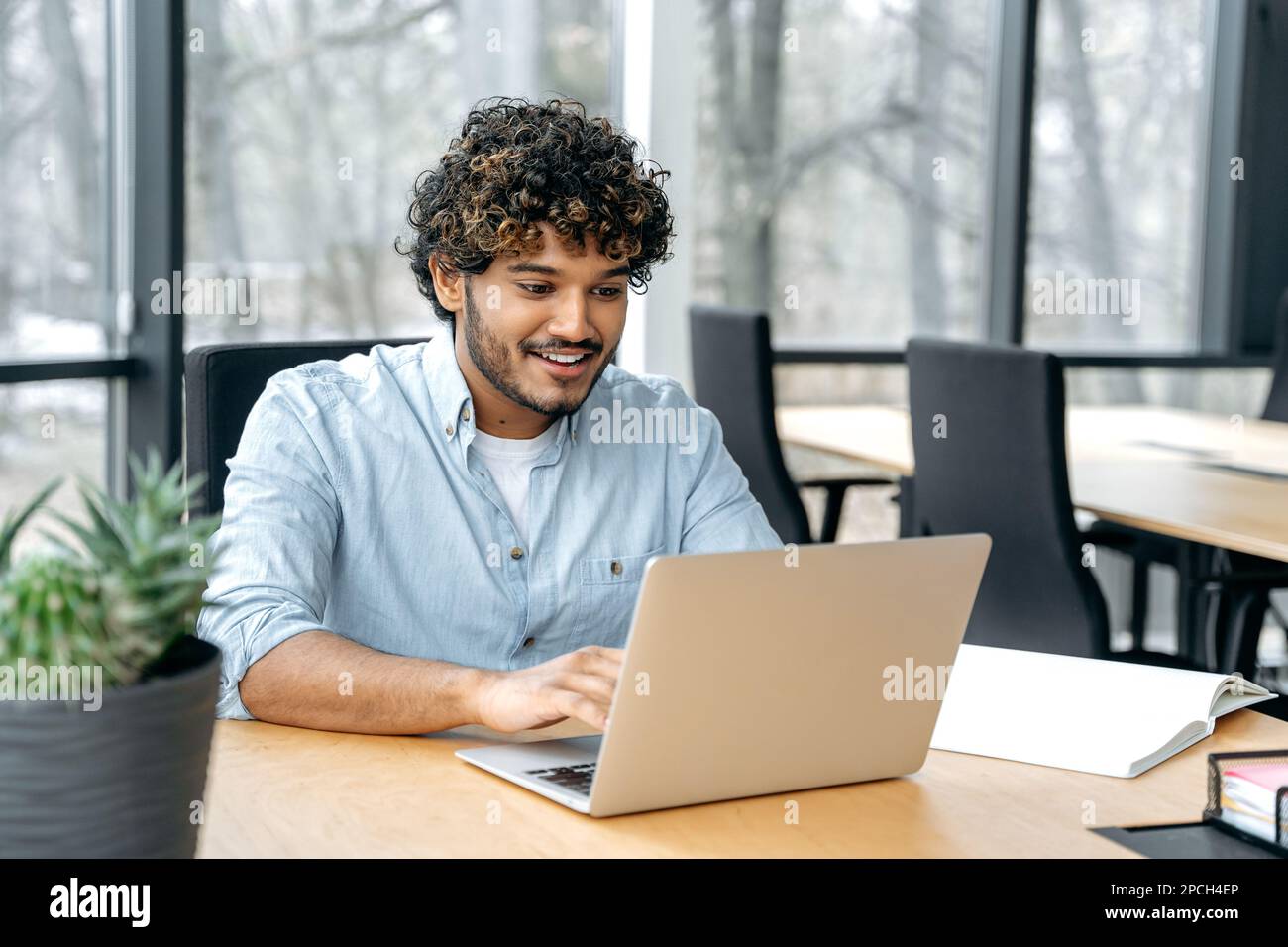 Positive satisfied Indian man, company employee, executive, sits at a ...