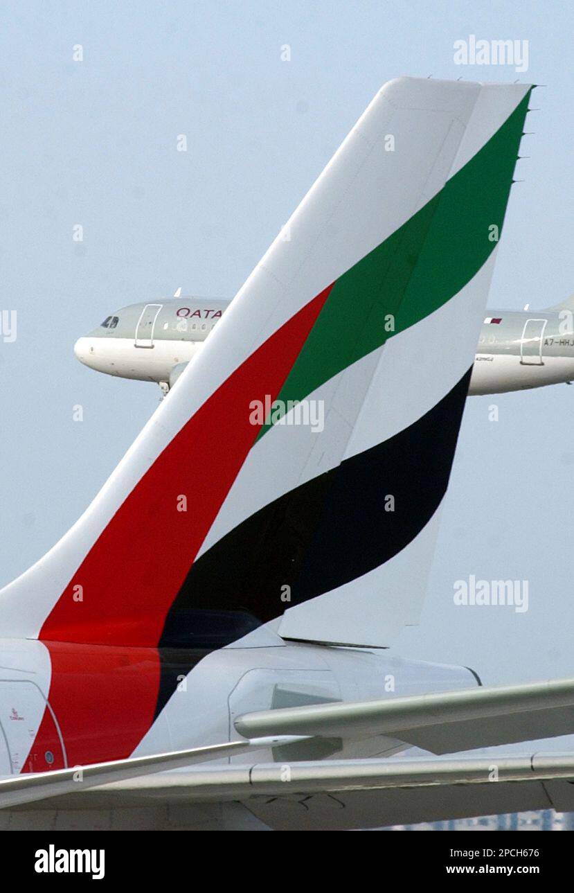 ** FILE ** A plane takes off behind the tail of an Emirates aircraft at ...