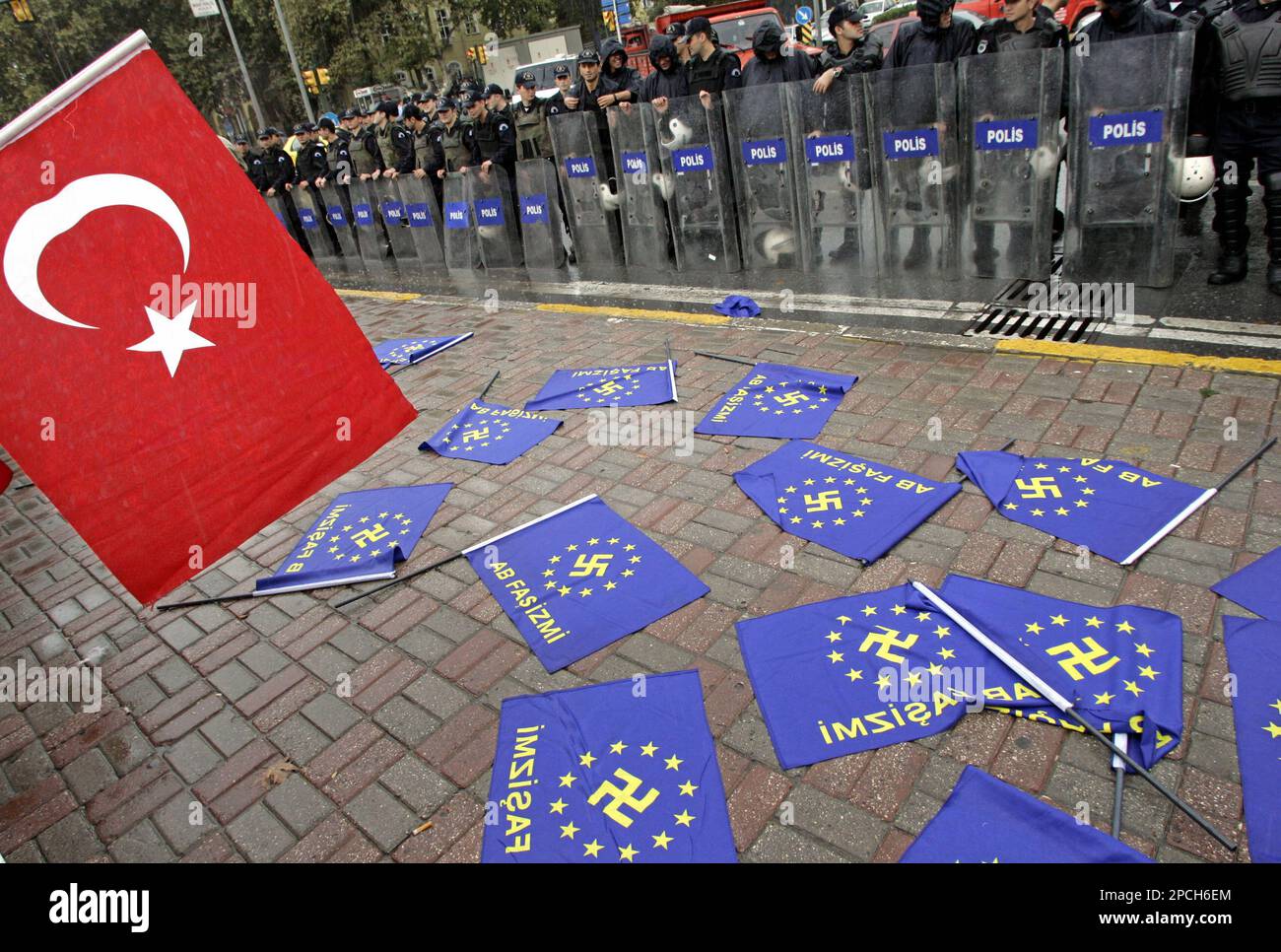 Turkish nationalists wave a national flag as the EU flags, adorned with ...