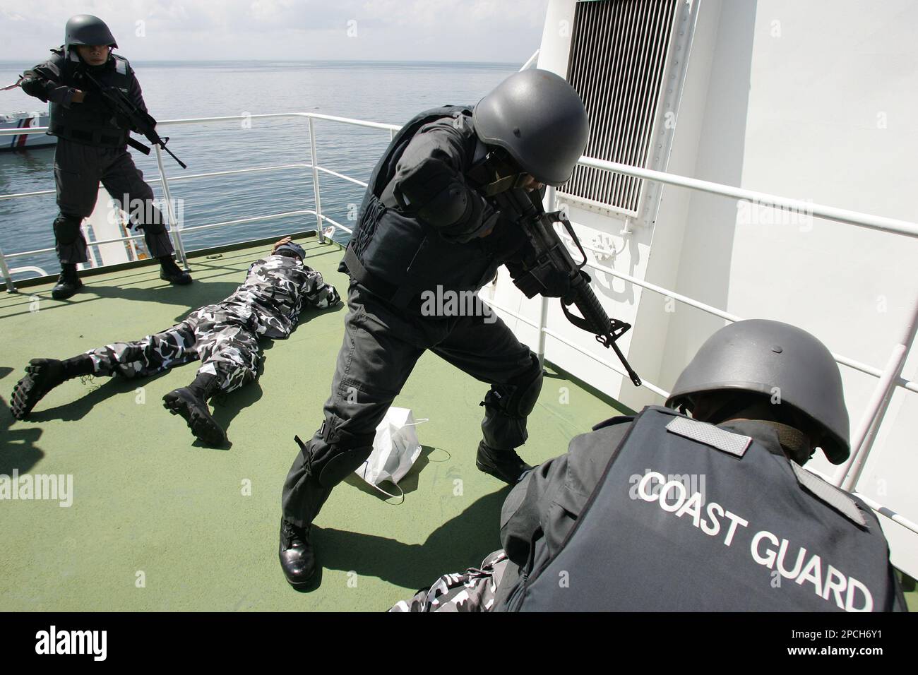 Philippine Coast Guard Special Operations Group point their guns at ...