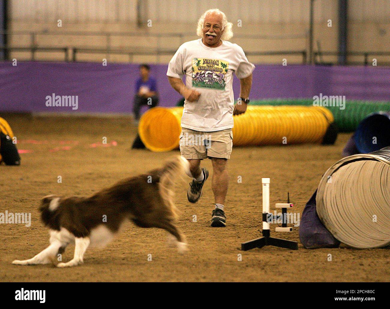 Don Cuda, of Hutchinson, Kan., finishes the tunnels event with his dog ...