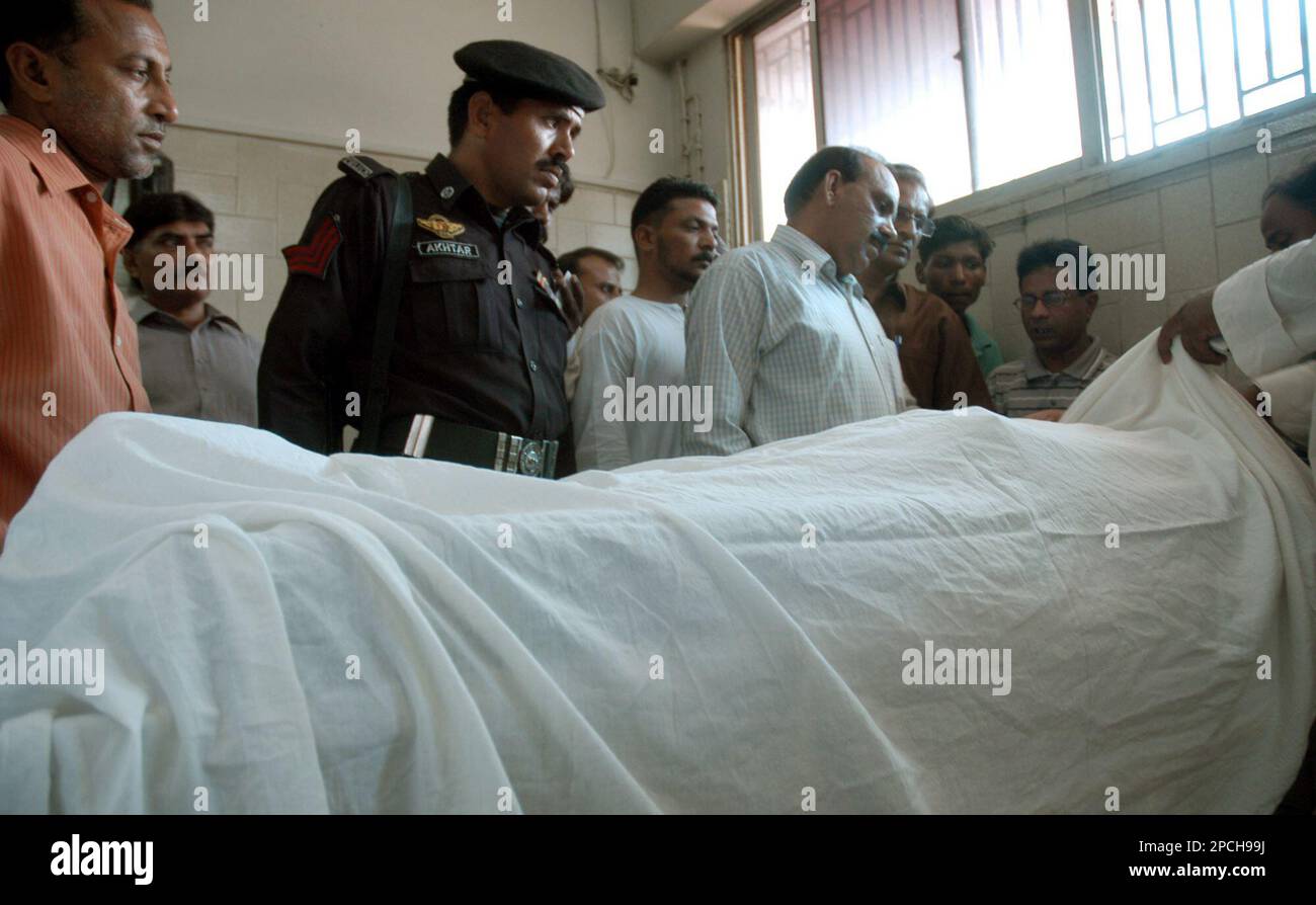 Pakistani officials look at the dead body of political party activist ...