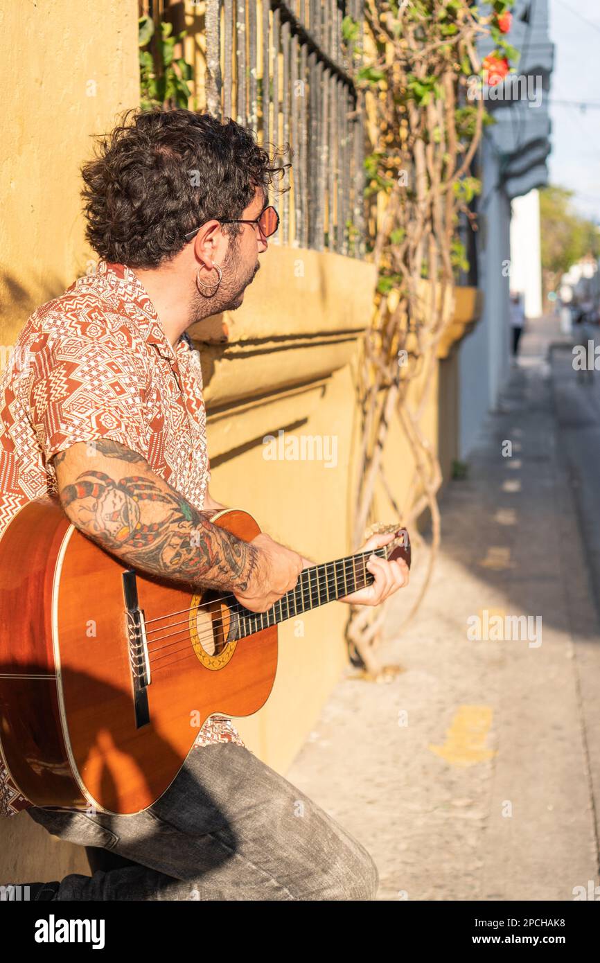 Male musician walking carrying guitar on his shoulder Stock Photo - Alamy