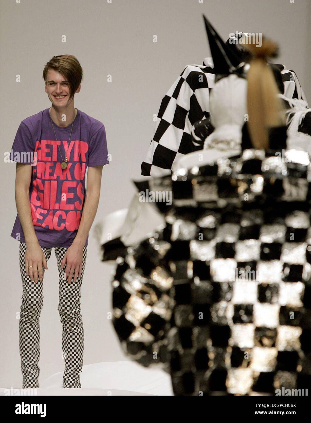 Designer Gareth Pugh, left, greets the audience on the catwalk after ...